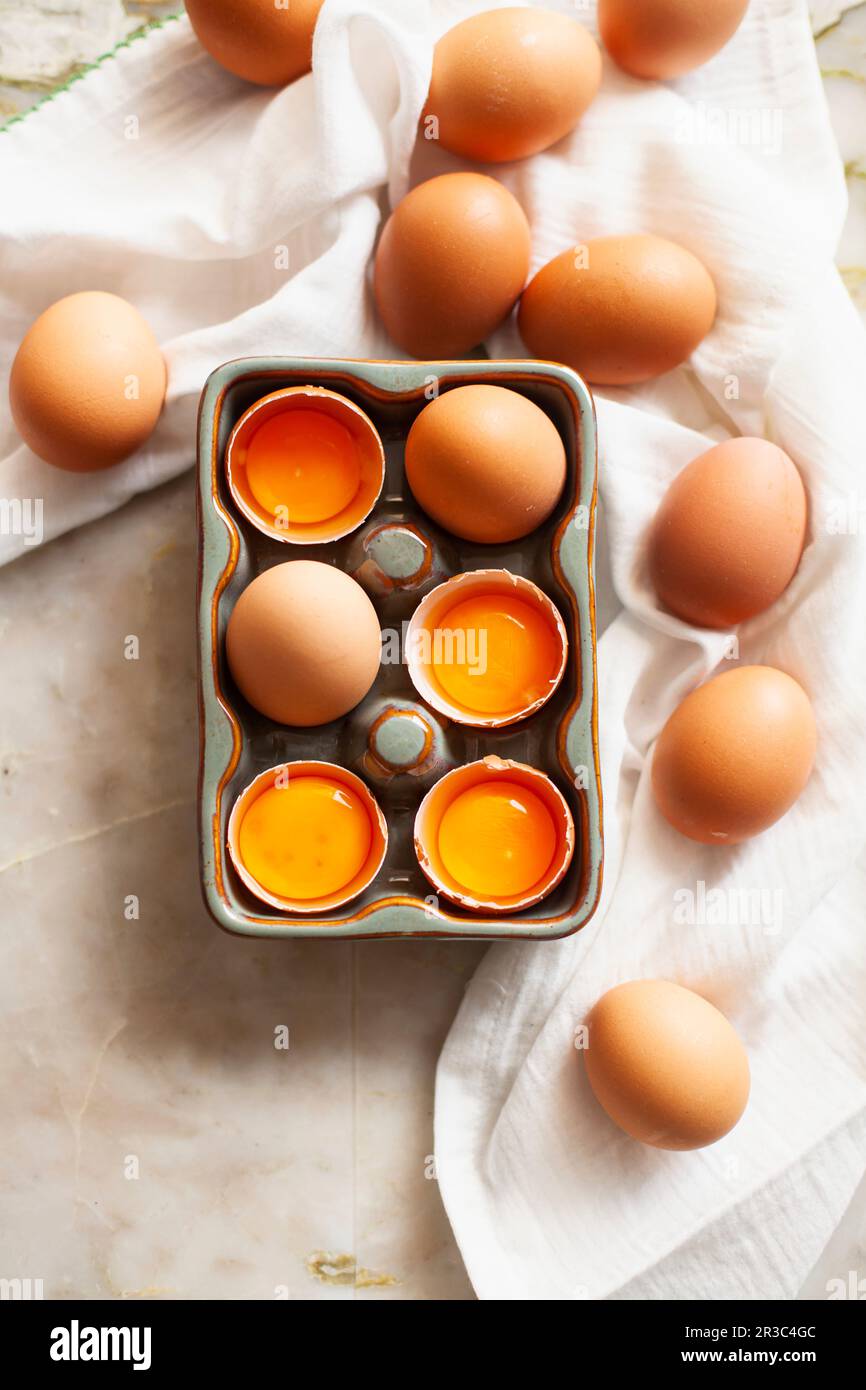 Whole and cracked eggs in an egg container Stock Photo - Alamy