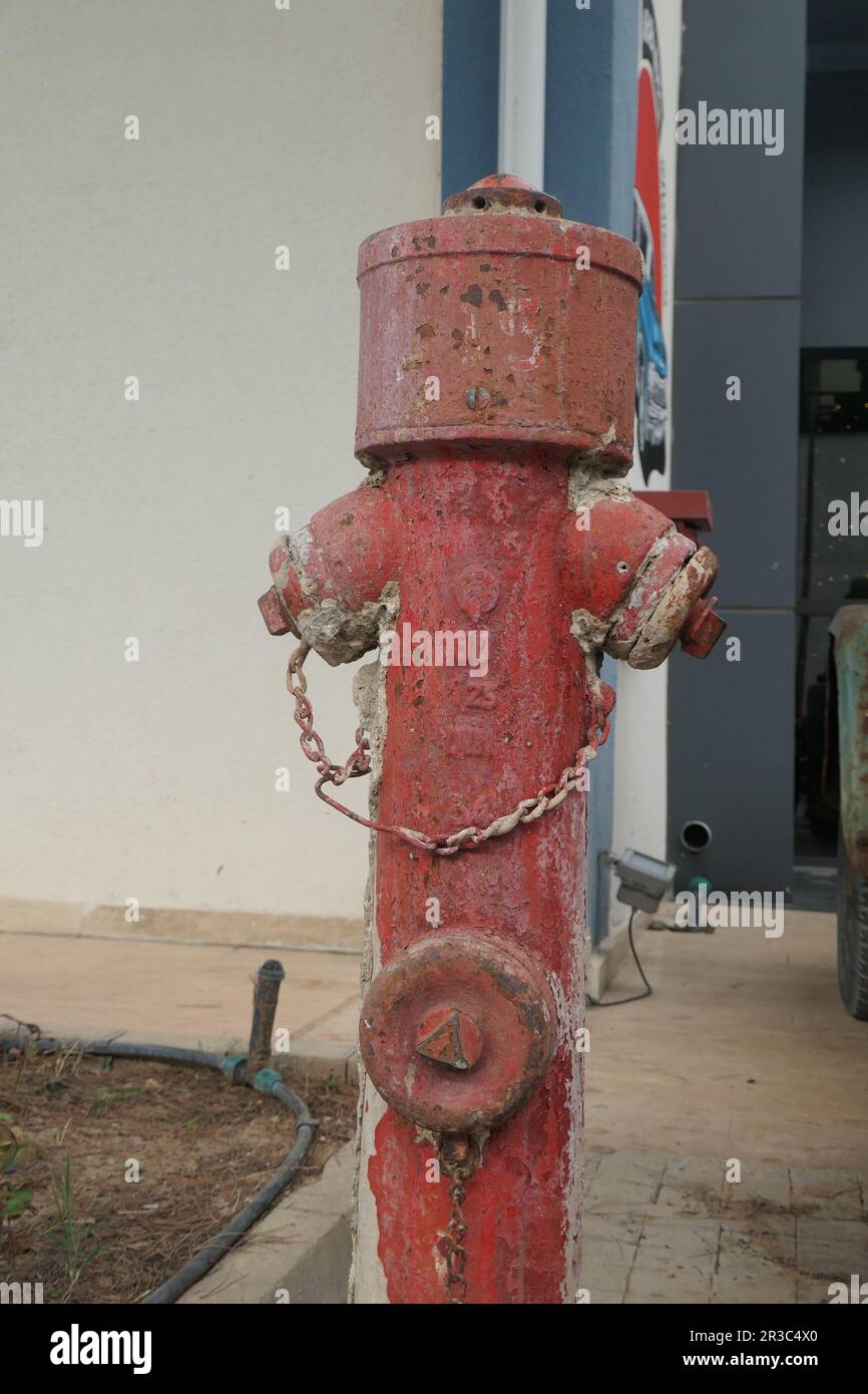 Old rusty red fire hydrant in front of the building Stock Photo - Alamy