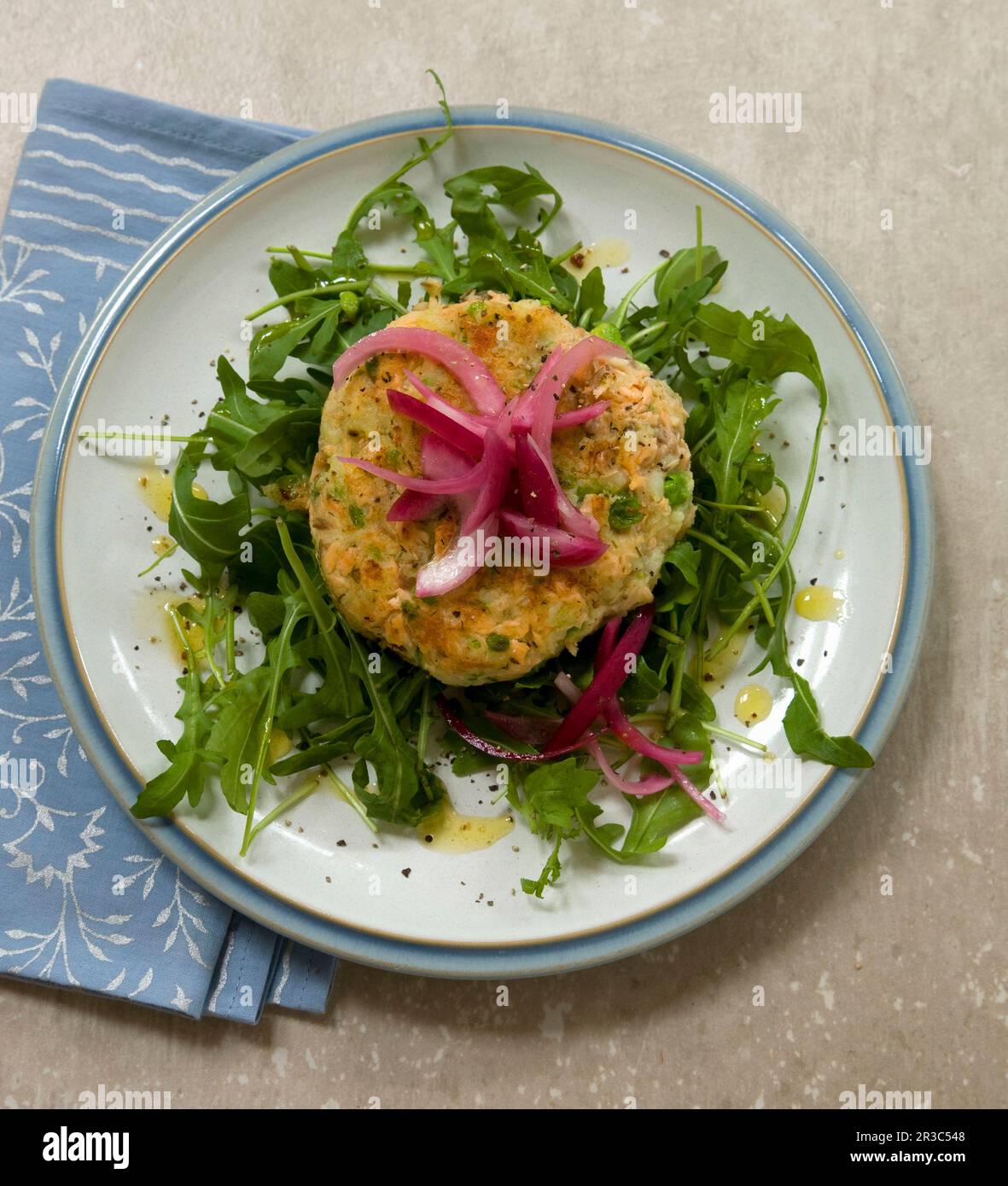 Salmon and pea fishcake with rocket and pickled red onions Stock Photo ...