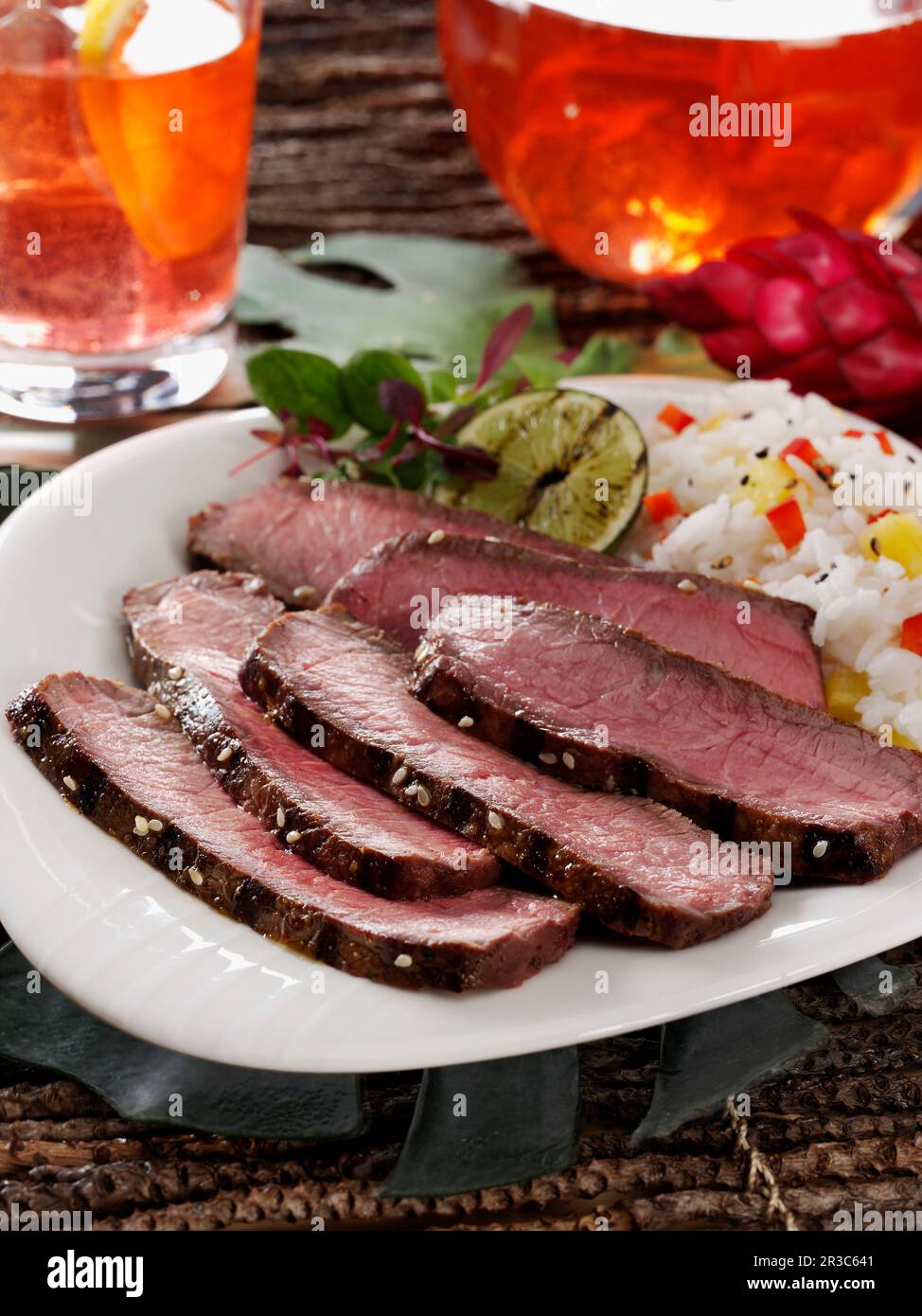 London broil beef with rice and a grilled lime Stock Photo - Alamy