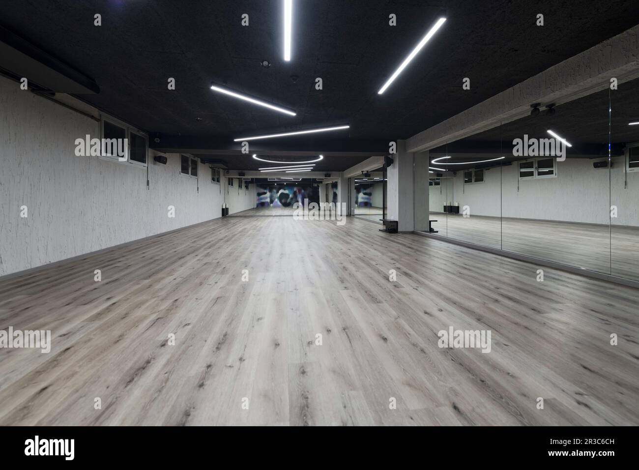 An empty dance hall with a glass wall adorned with decorative graffiti ...