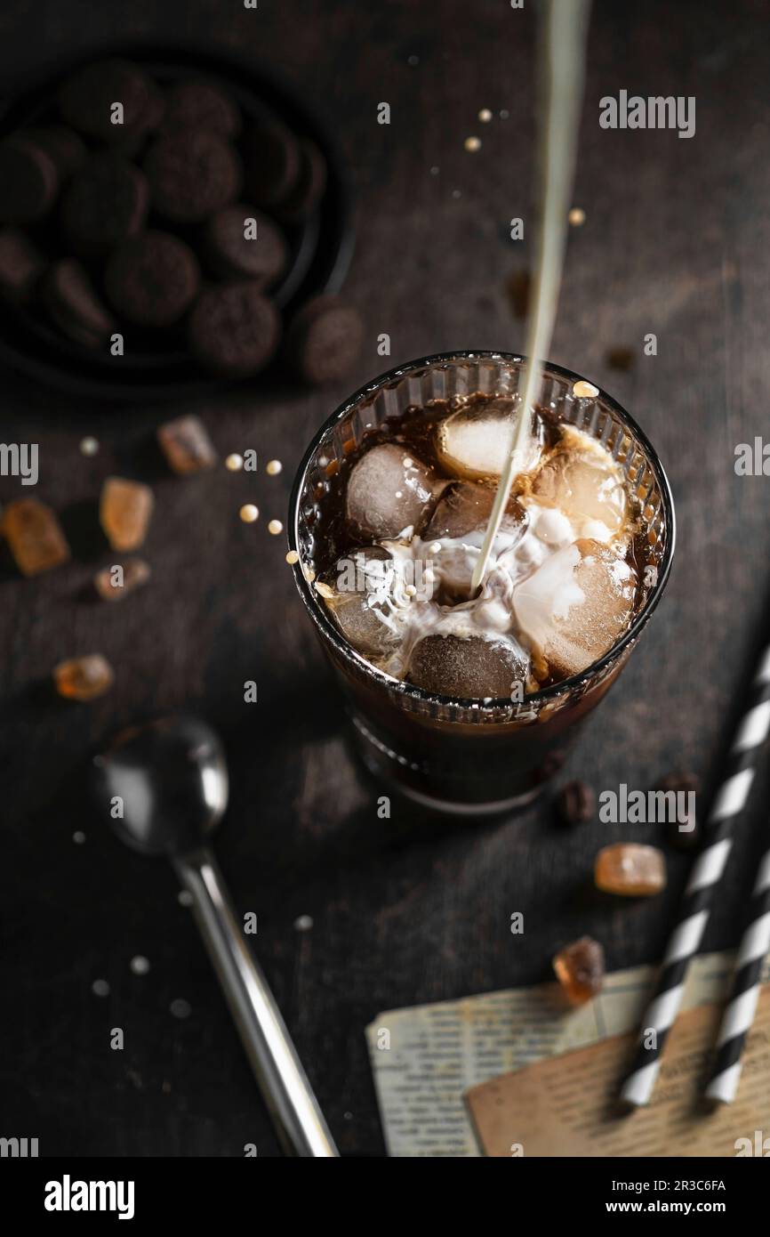 Iced coffee with milk splash Stock Photo - Alamy