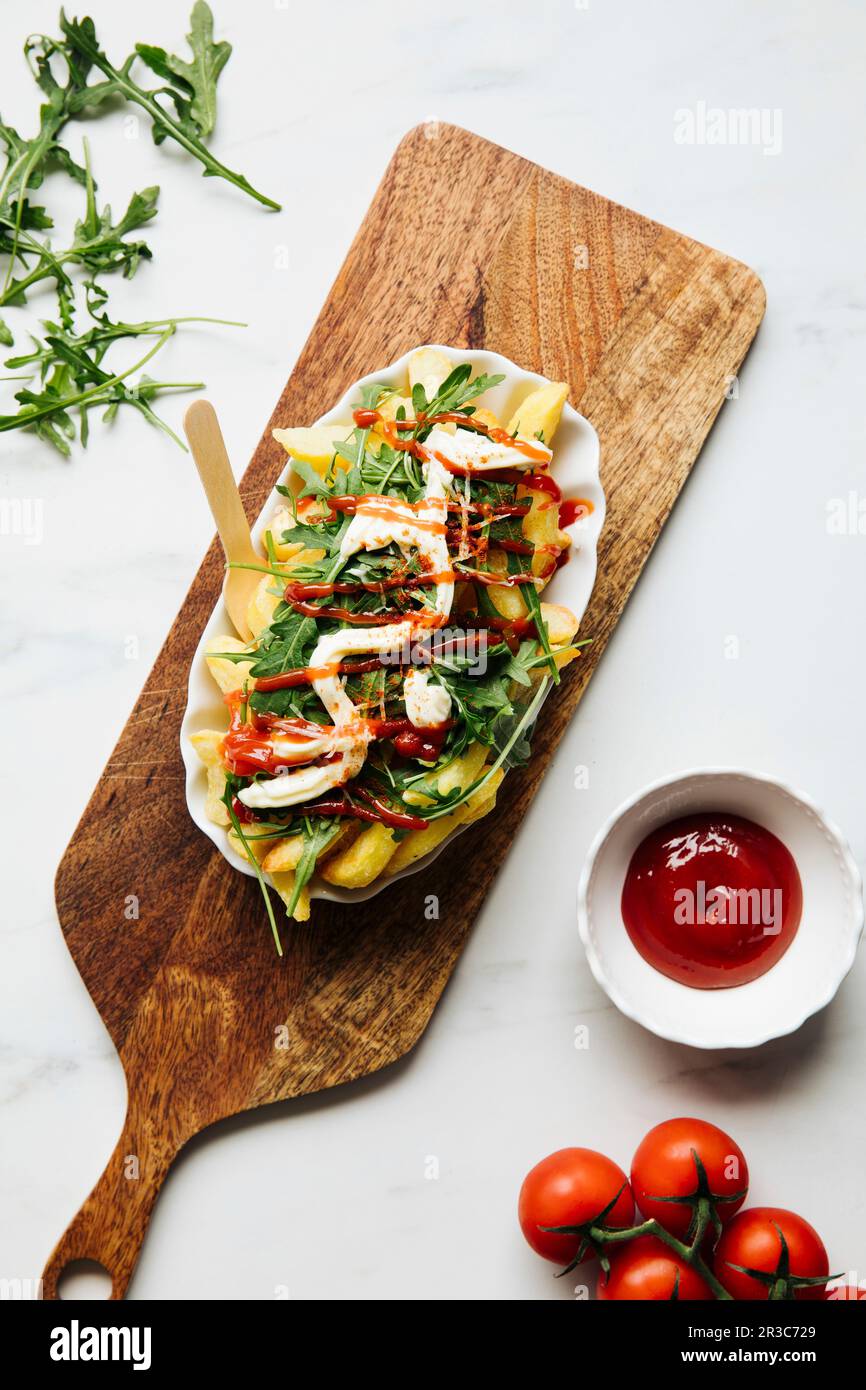 French fries with rocket, ketchup and vegan mayonnaise Stock Photo - Alamy