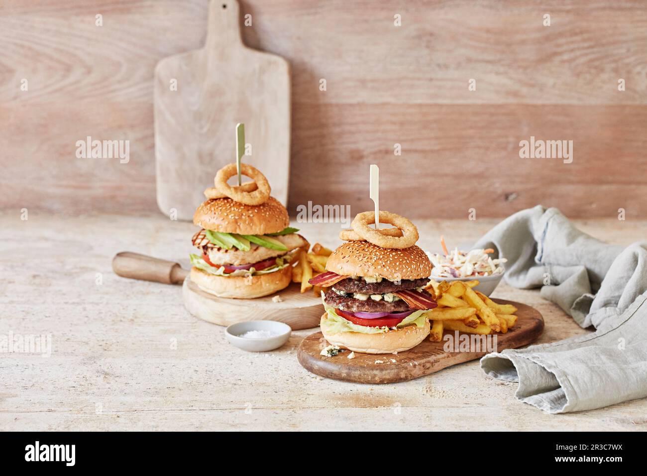 Blue cheese burger and a chicken burger topped with onion rings on a ...