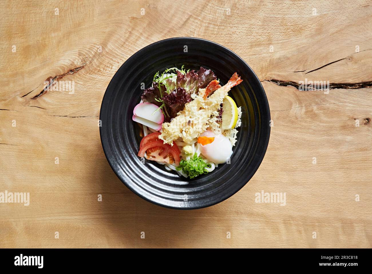 Ramen with udon noodles, salad, egg, tempura prawns and spring onion ...