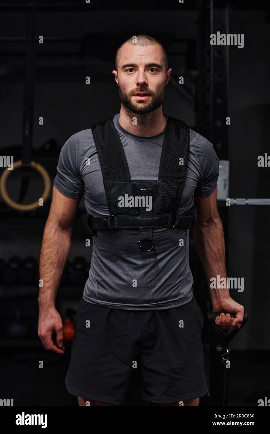 A muscular man working arm exercises in a modern gym, showcasing his ...