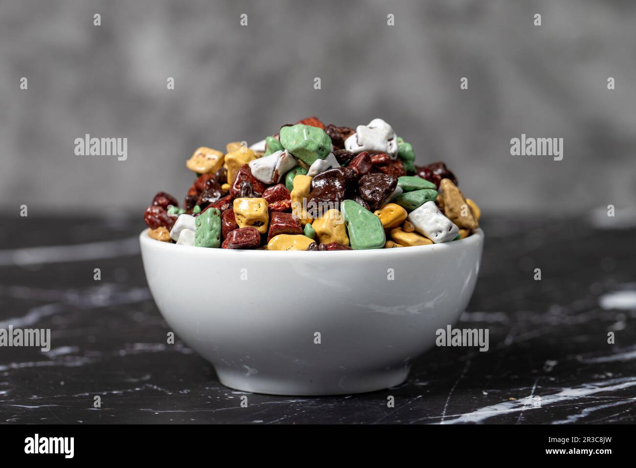 Colorful chocolate candy stones. Stone chocolate dragee in ceramic bowl ...