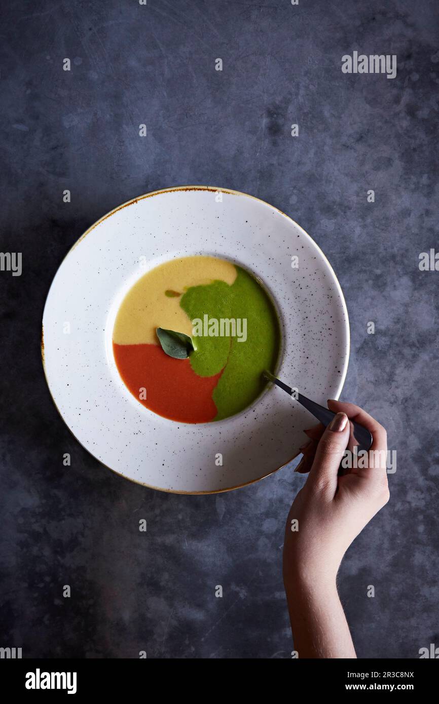 Tri coloured soup being stirred Stock Photo - Alamy