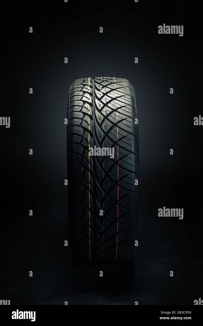 Brand new modern car tyre on a black background. Studio shot Stock ...