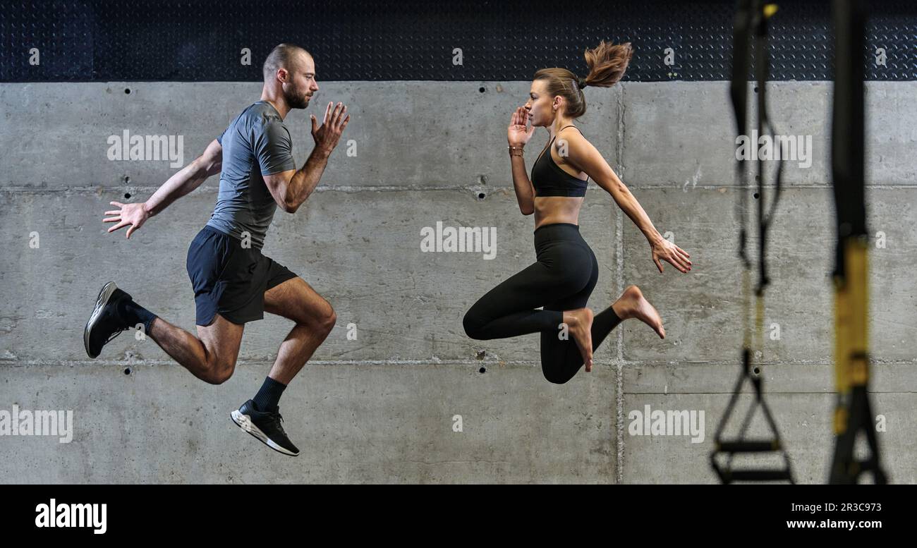 A fit couple exercising various types of jumps in a modern gym ... A fit couple exercising various types of jumps in a modern gym ...