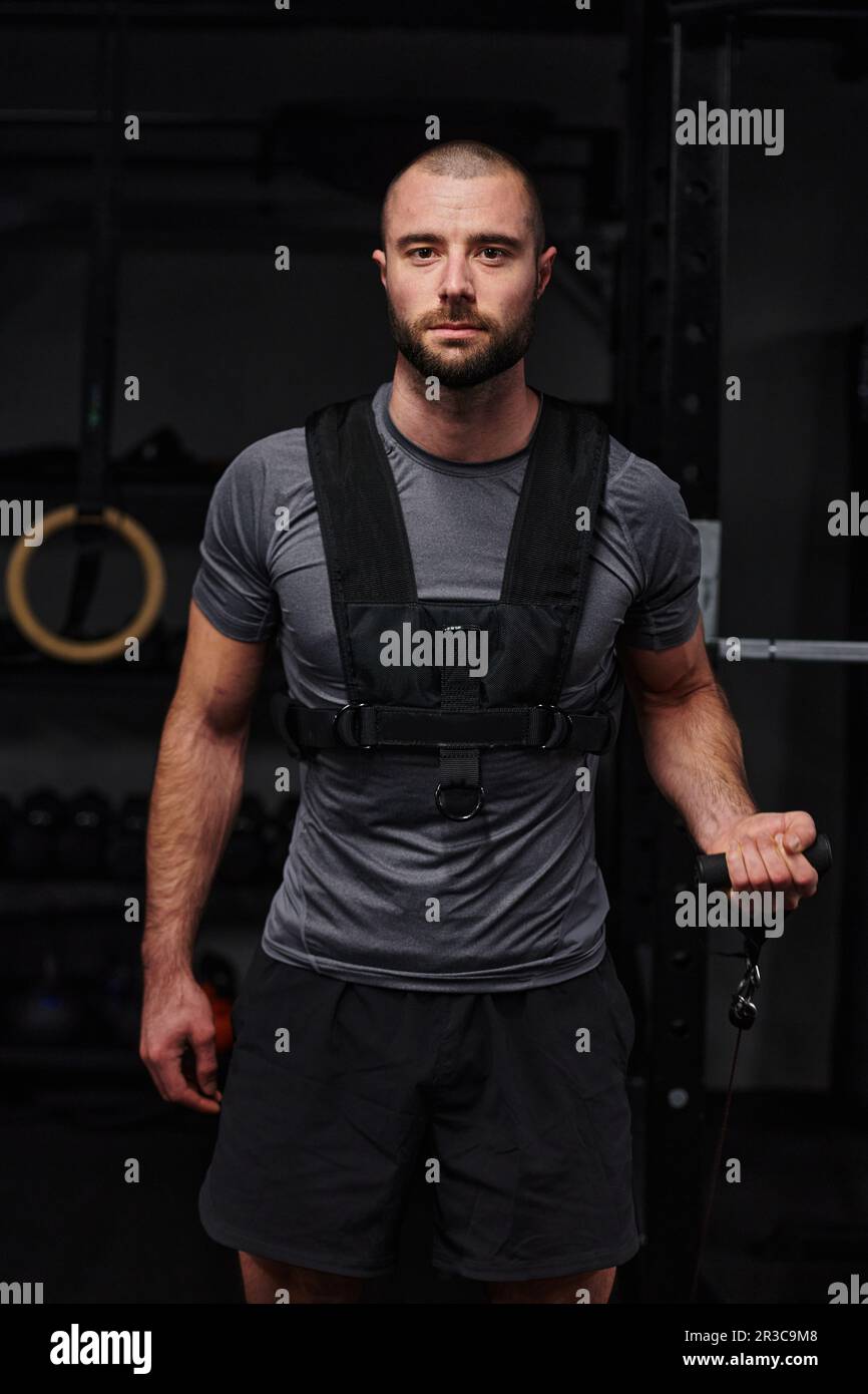 A muscular man working arm exercises in a modern gym, showcasing his ...