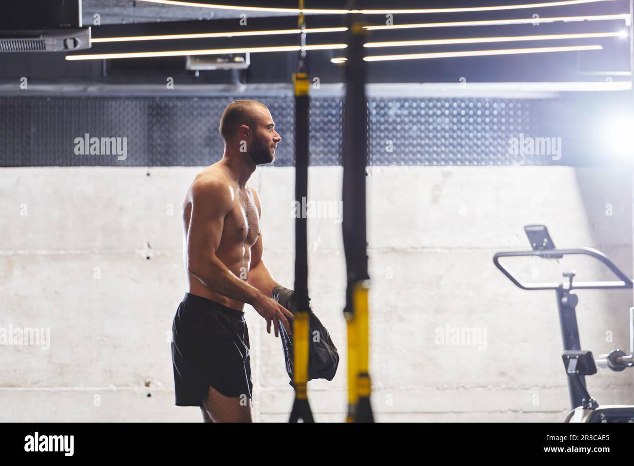 A muscular man in the gym, preparing for his workout, exudes ...