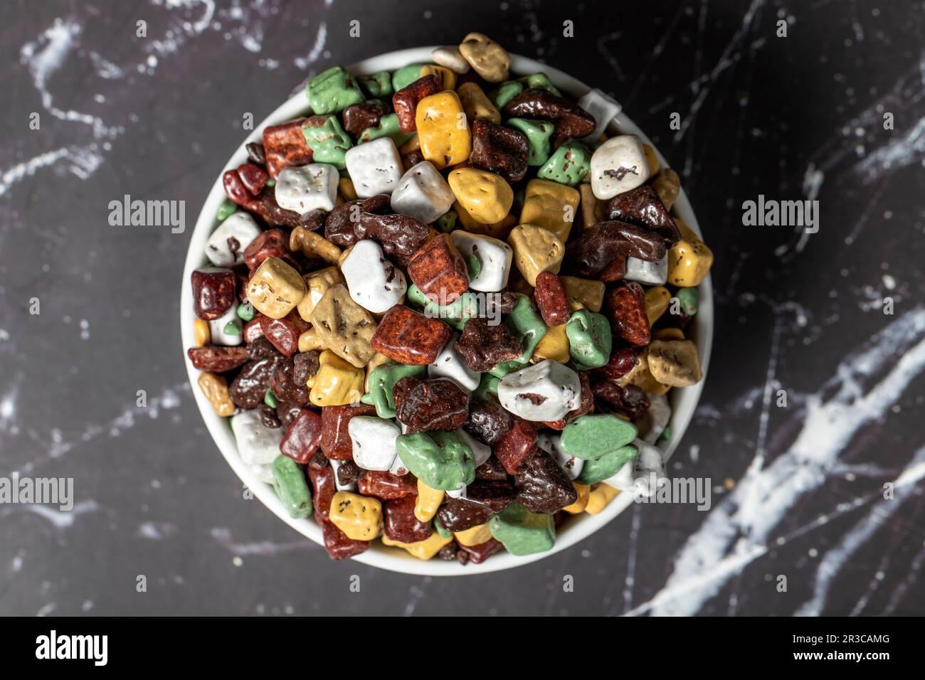 Colorful chocolate candy stones. Stone chocolate dragee in ceramic bowl ...