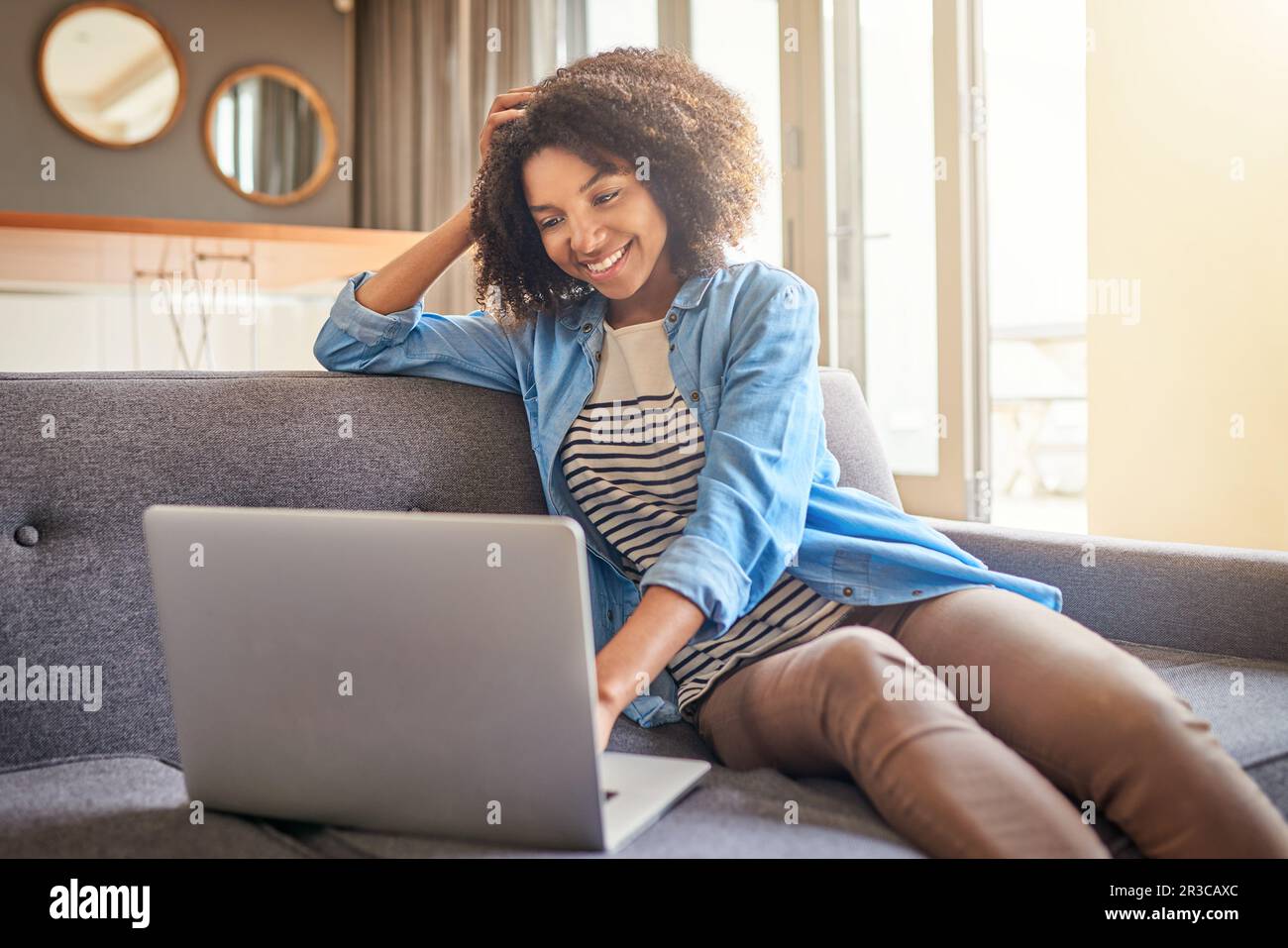 Technology, black woman with laptop and on sofa of her living room at ...