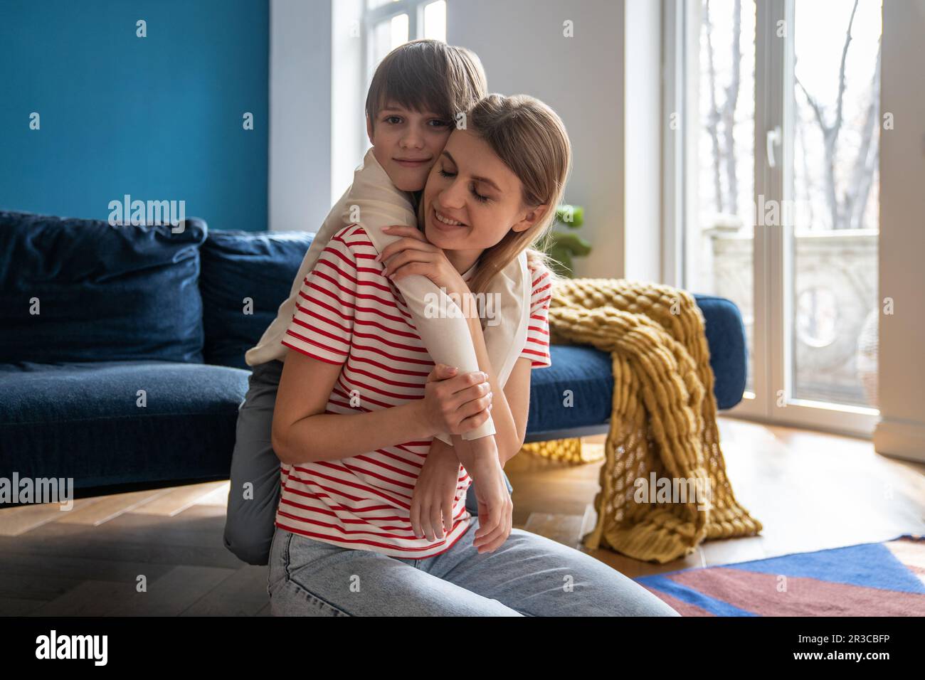 Child boy hugging mother from back smiling at camera Stock Photo - Alamy