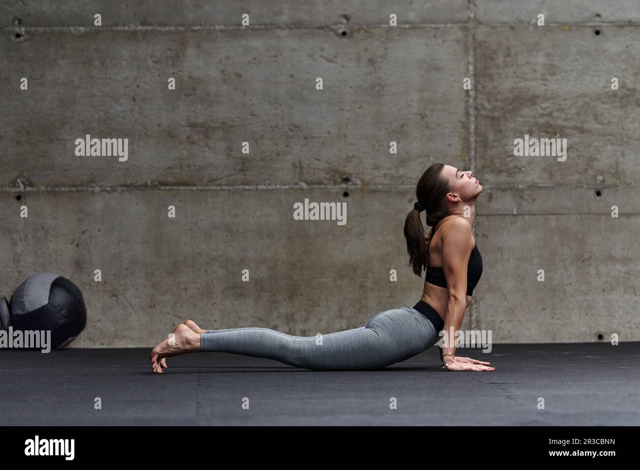 Fit woman in a modern gym working flexibility and strength through ...