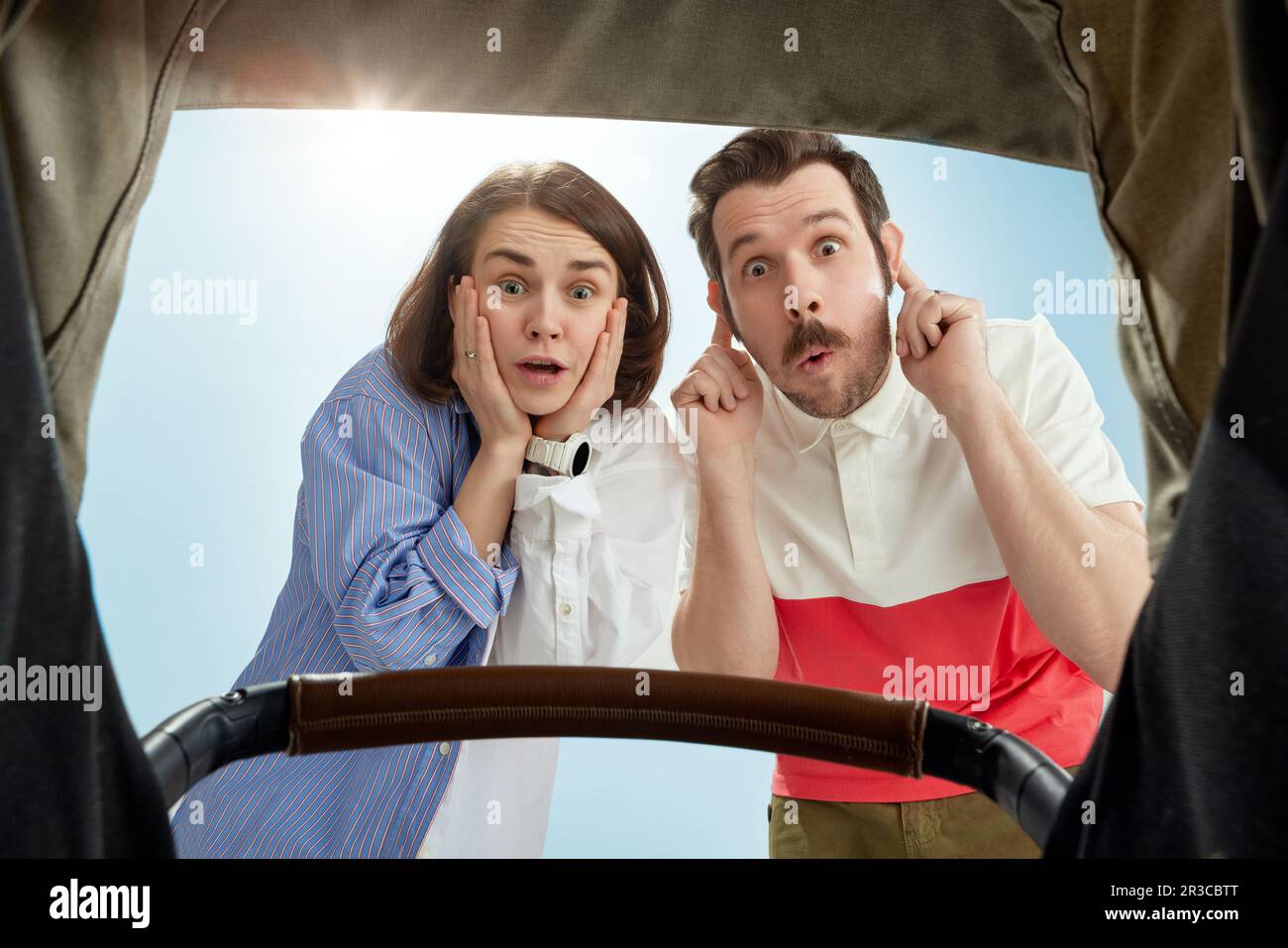 Making funny faces. Man and woman, young parents looking at newborn kid ...