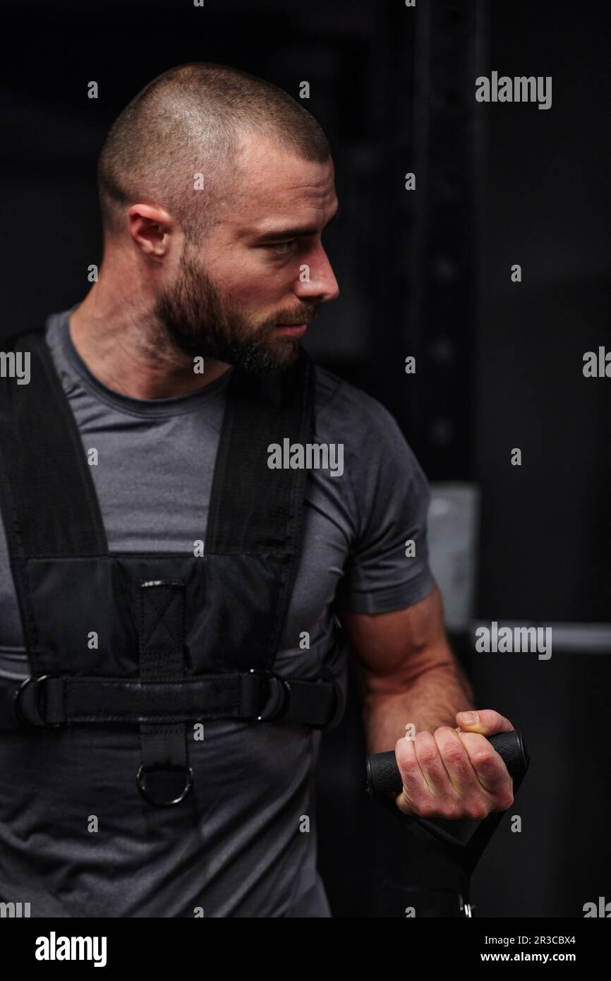A muscular man working arm exercises in a modern gym, showcasing his ...