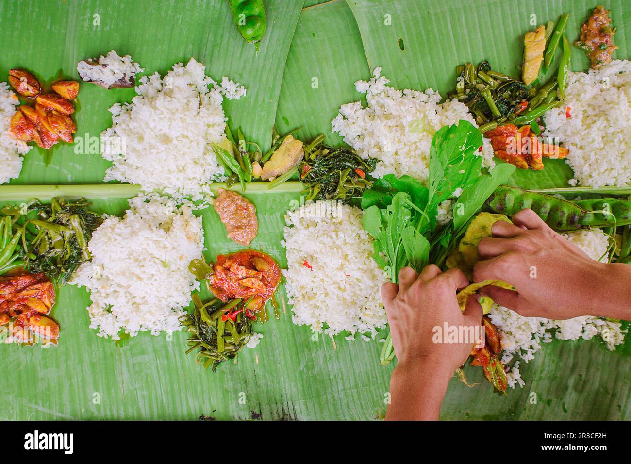 Nasi liwet, a traditional Indonesian food served on a banana leaf, is ...