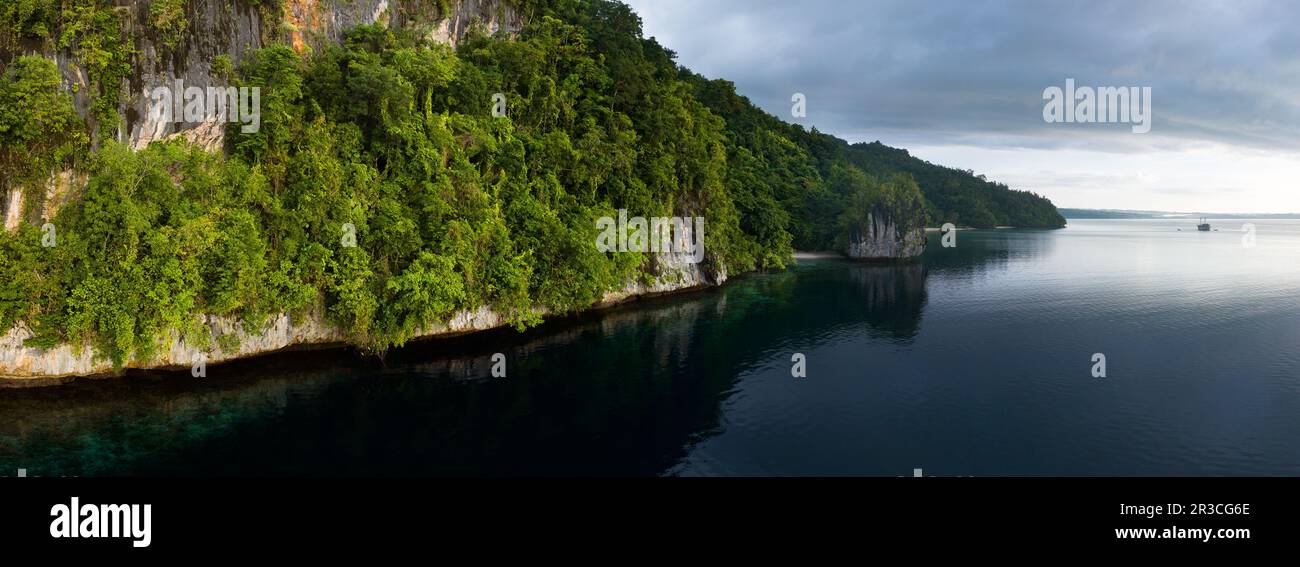 Calm seas slowly erode an undercut in a limestone island in West Papua ...