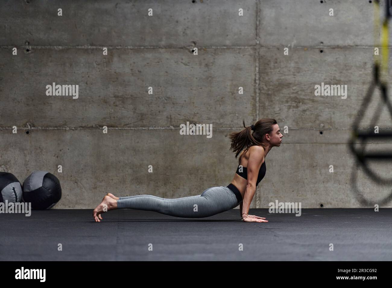 Fit woman in a modern gym working flexibility and strength through ...