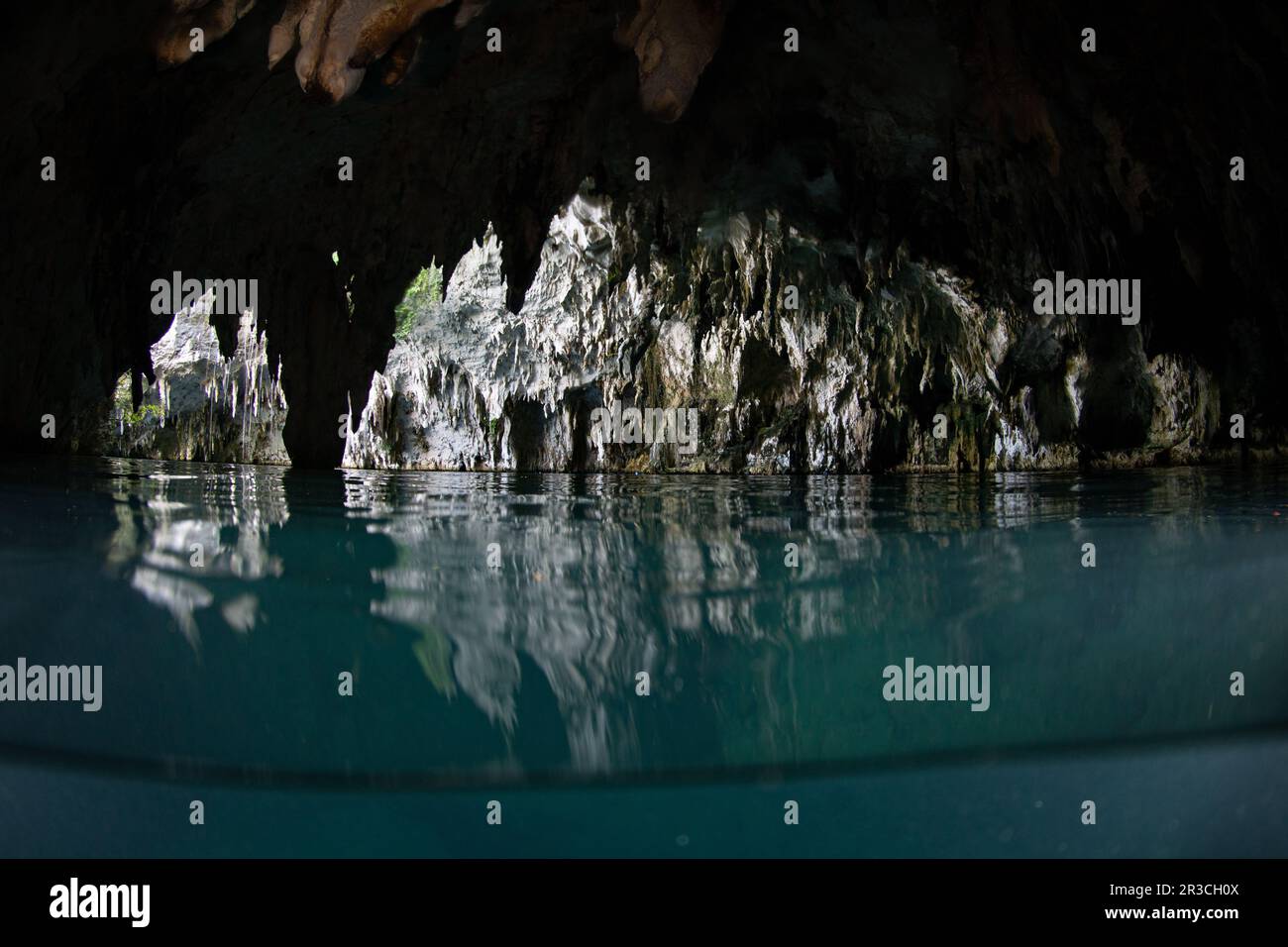 Stalactites hang down from the roof of a collapsed, water-filled cave ...