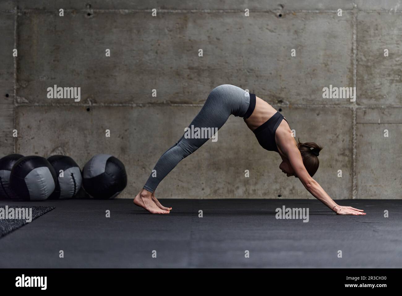 Fit woman in a modern gym working flexibility and strength through ...