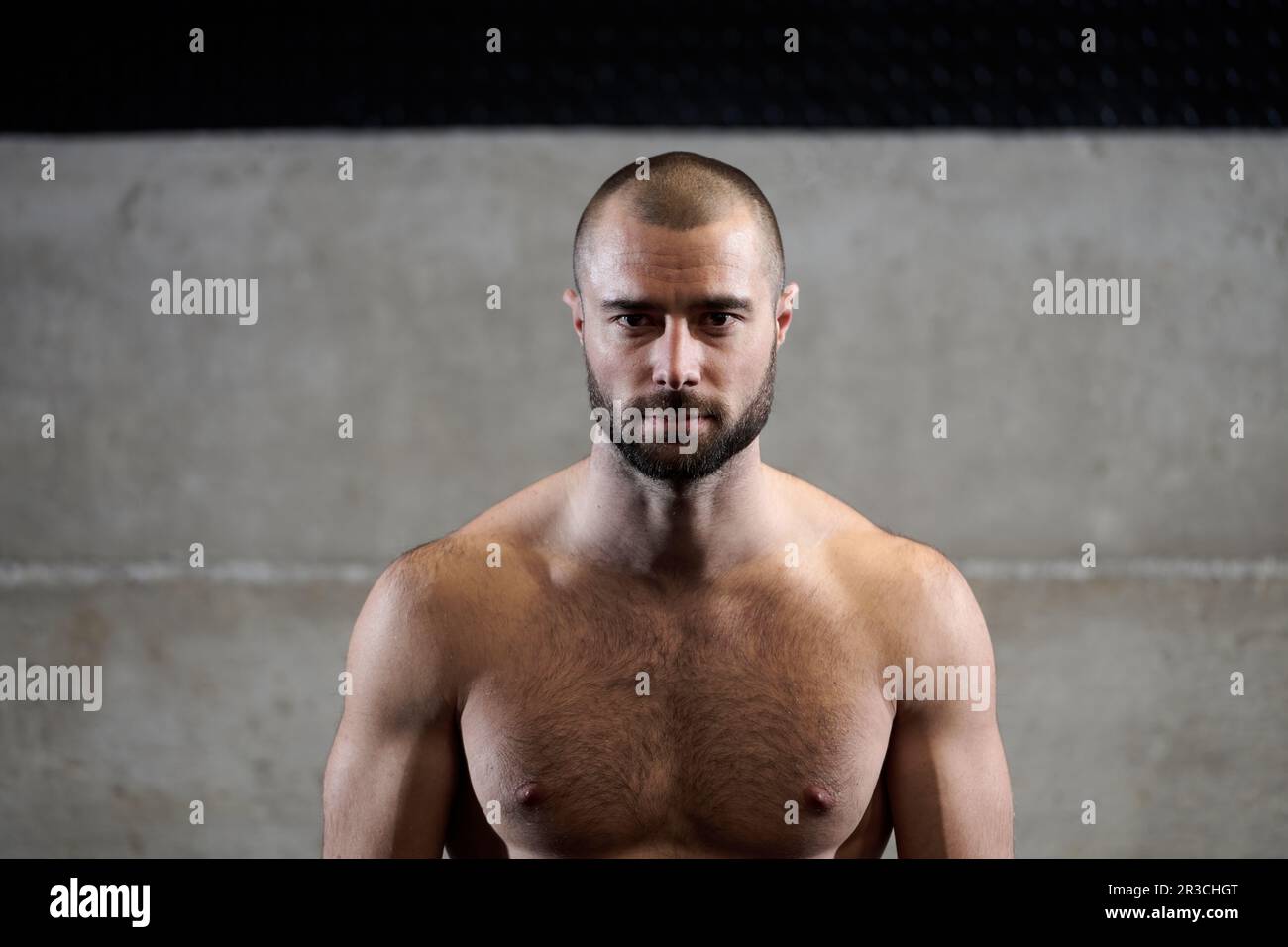 A muscular man poses in the gym, showcasing his strength and dedication ...