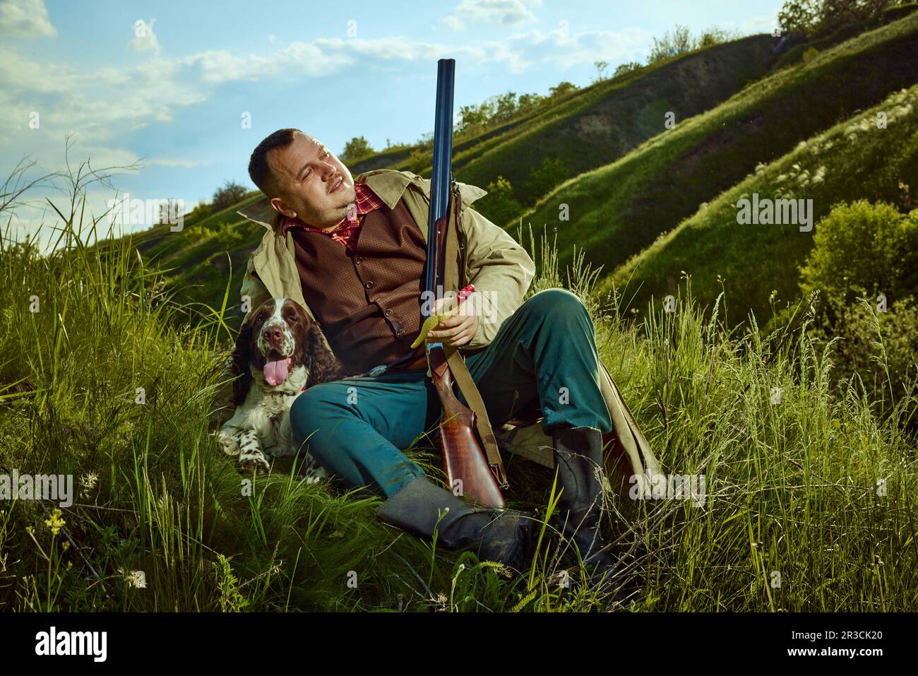 Obedient hunter dog English springer spaniel sitting with his owner ...