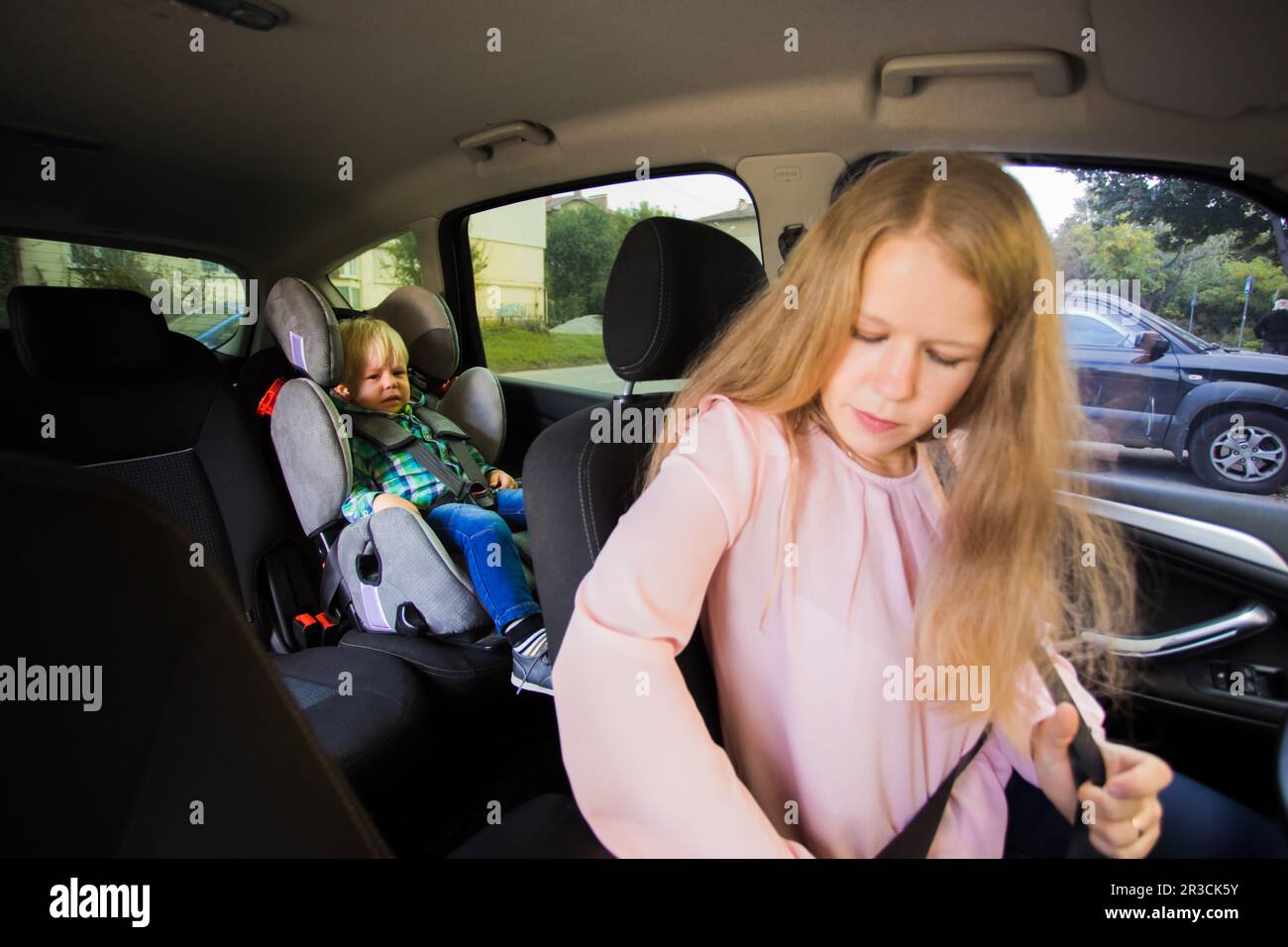 Woman fastens the seat belt in the car during boy is crying Stock Photo ...