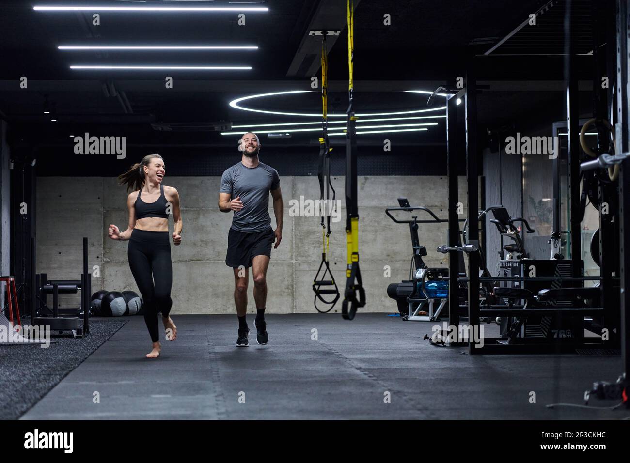 A fit couple in a modern gym, engaging in running exercises and ... A fit couple in a modern gym, engaging in running exercises and ...
