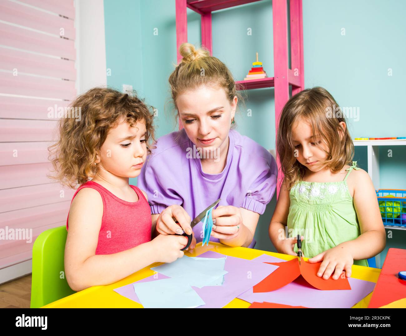 The kids perform a creative task with the teacher Stock Photo - Alamy