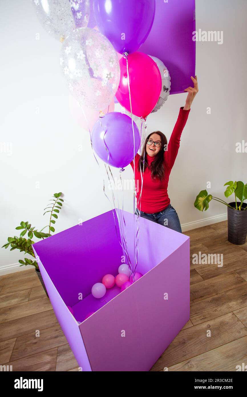 The woman is opening a large gift box for a holiday Stock Photo - Alamy