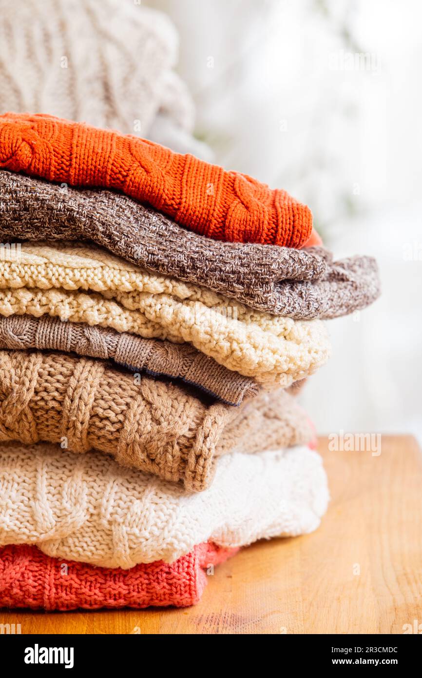 Knitted clothes are folded in one heap Stock Photo - Alamy
