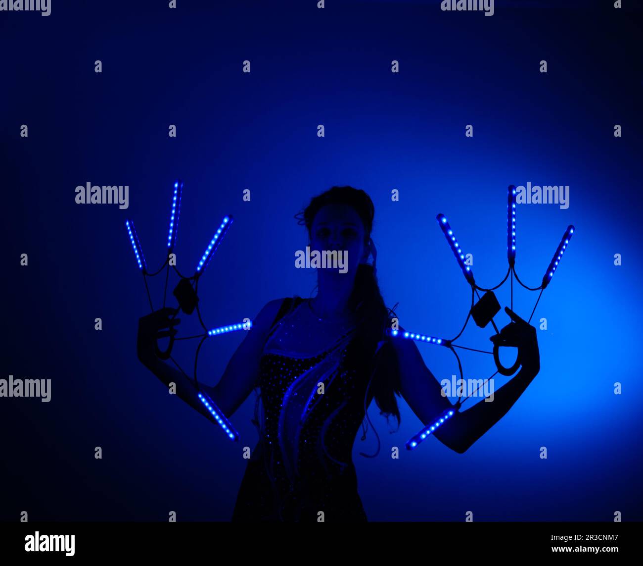 Woman in blue light dancing while light show Stock Photo - Alamy