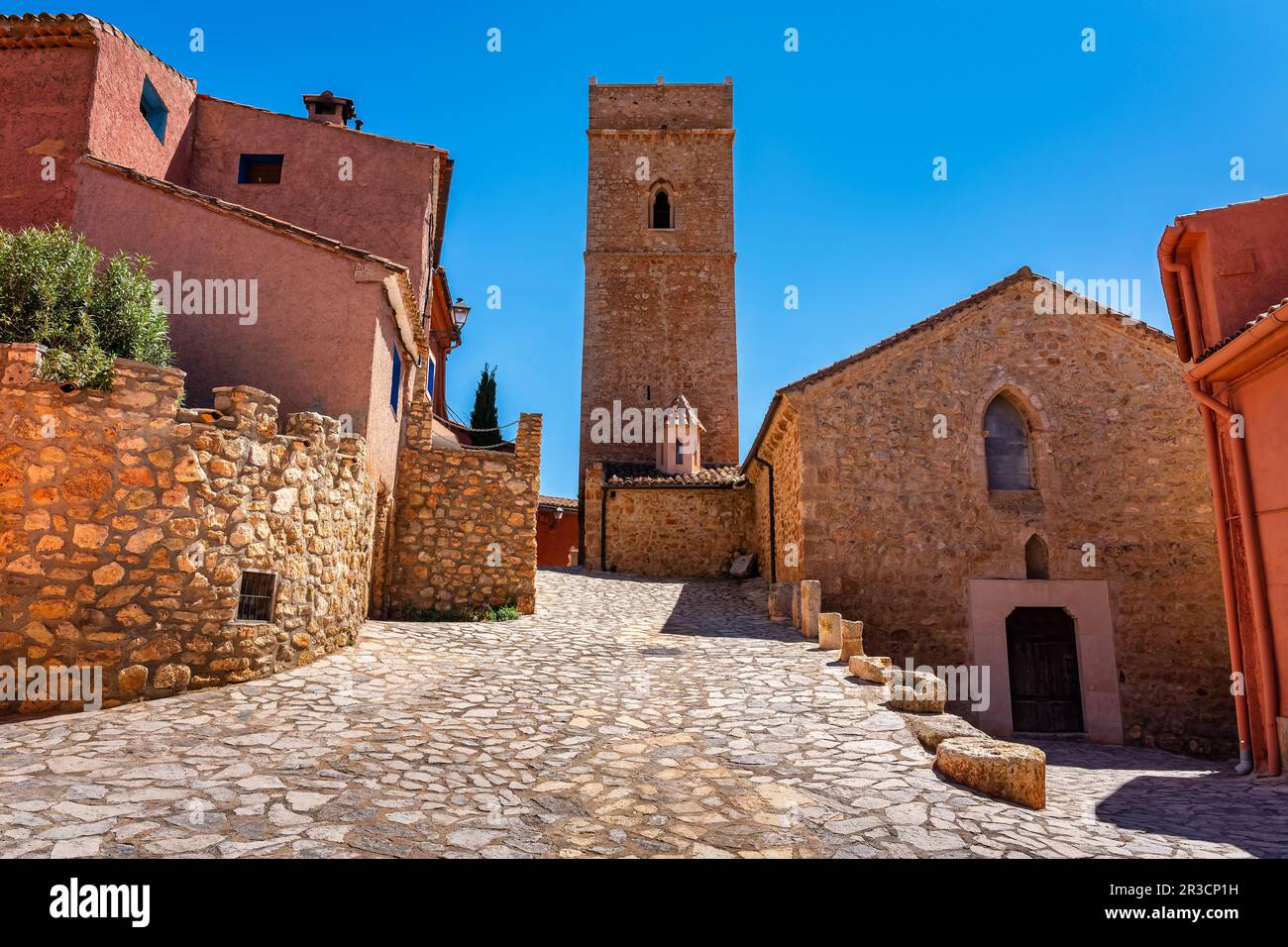 Tower of the medieval church next to the old stone houses of the ...