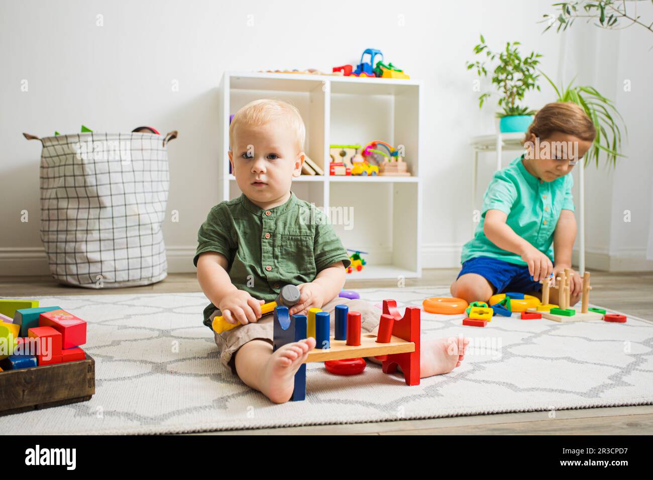 Toddler kid and baby play with educational toys Stock Photo - Alamy