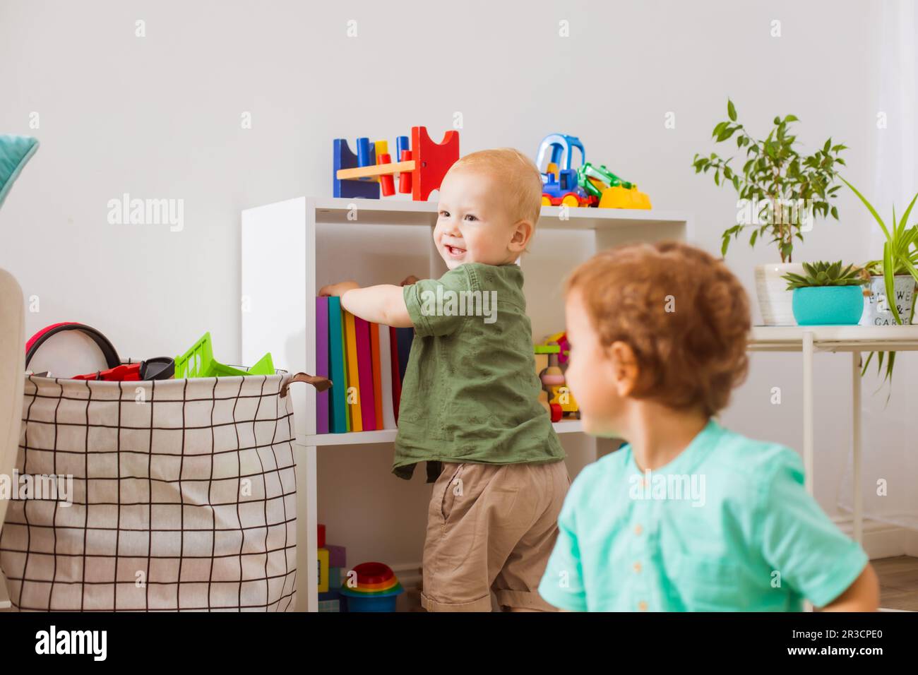 Two babies play and develop in the playroom Stock Photo - Alamy