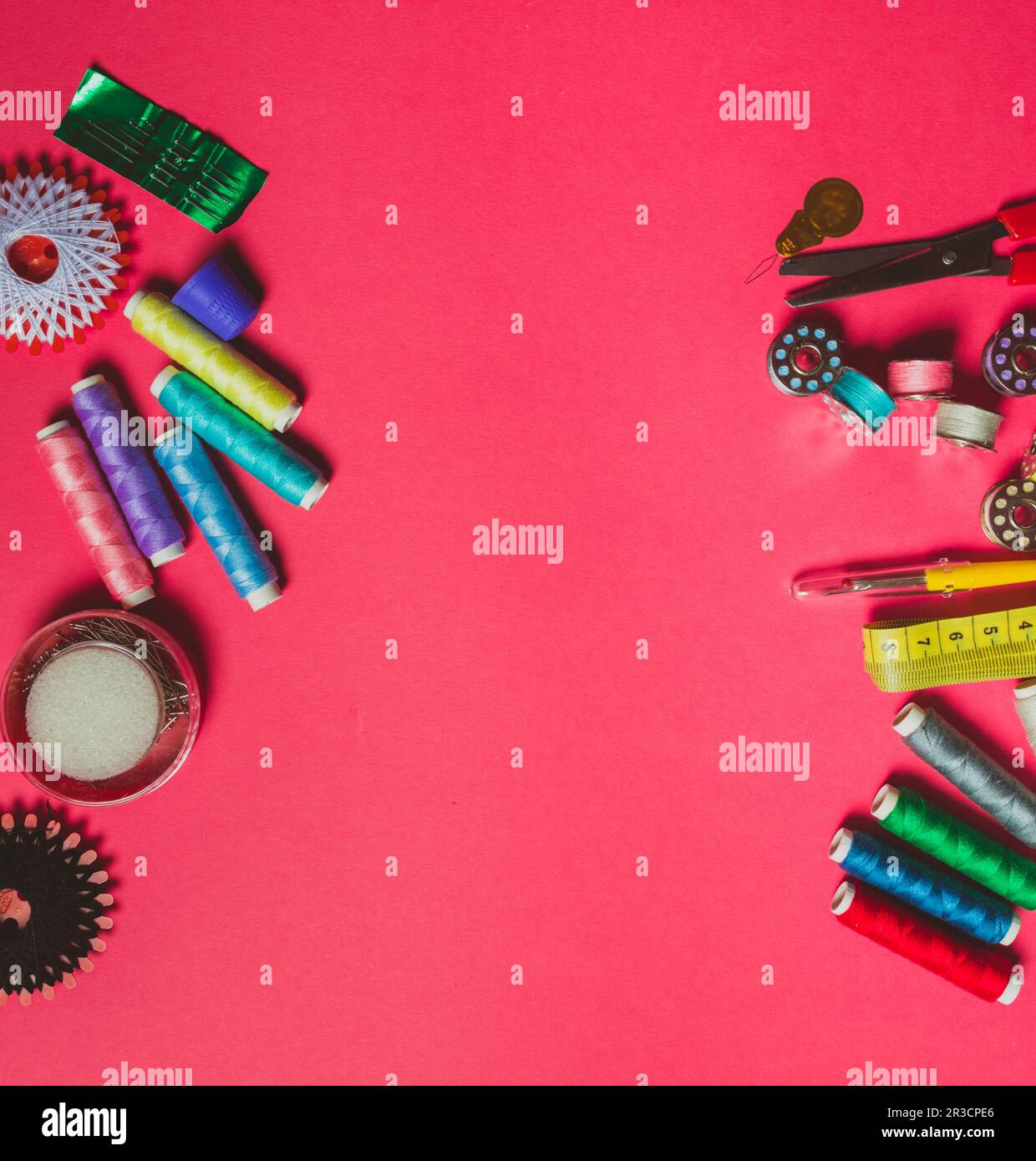 Colorful threads and spools on bright pink background Stock Photo - Alamy