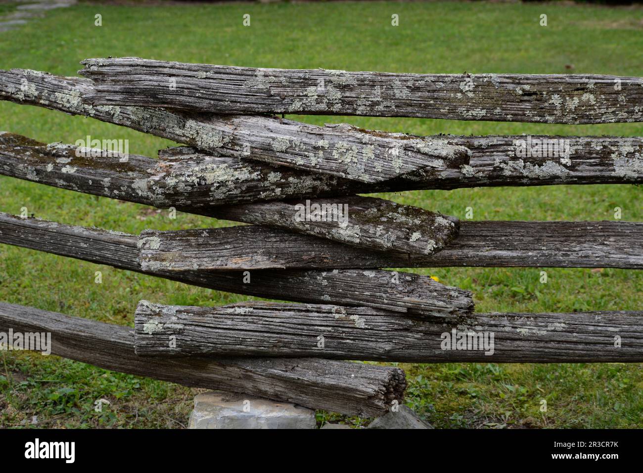 A rustic split rail fence in front of a 19th century log cabin in a ...