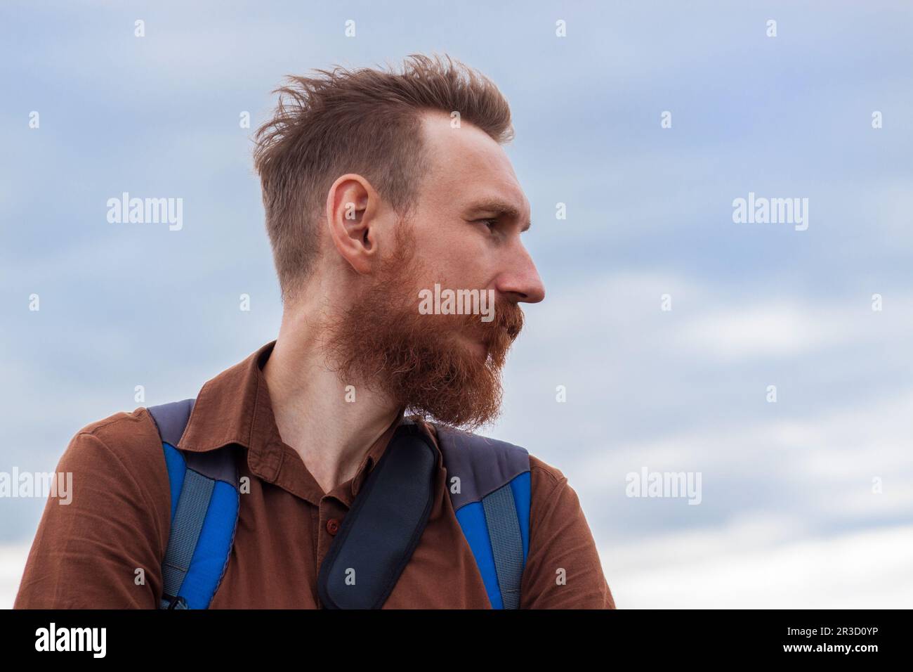 Handsome hipster man with lush beard and mustache on blue cloudy sky ...