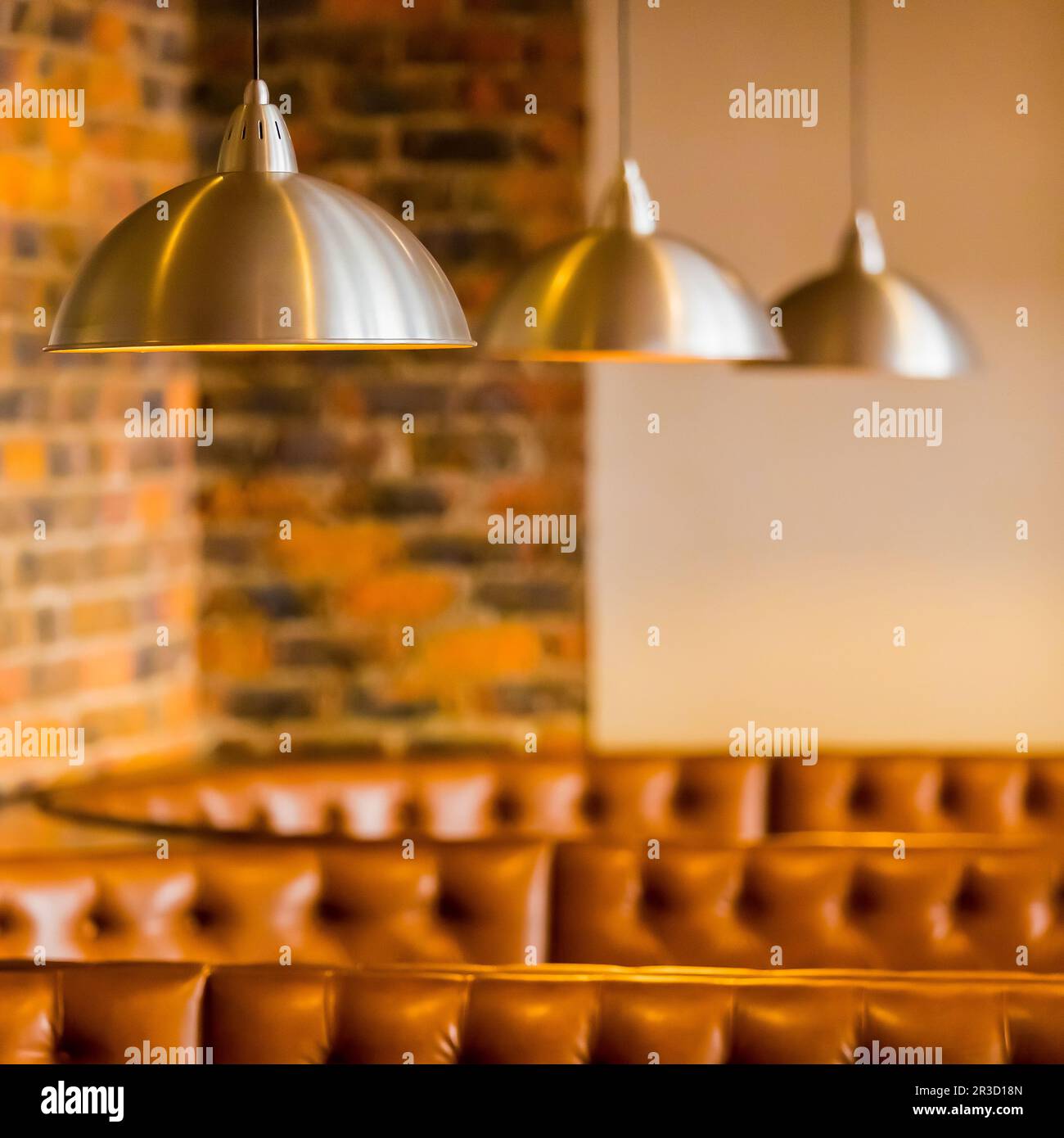 Brown leather restaurant booths with hanging stainless steel ceiling ...