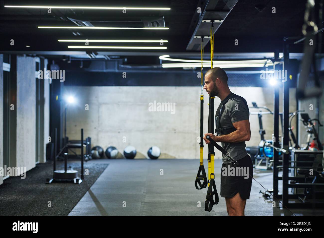 A muscular man in the gym, preparing for his workout, exudes ...