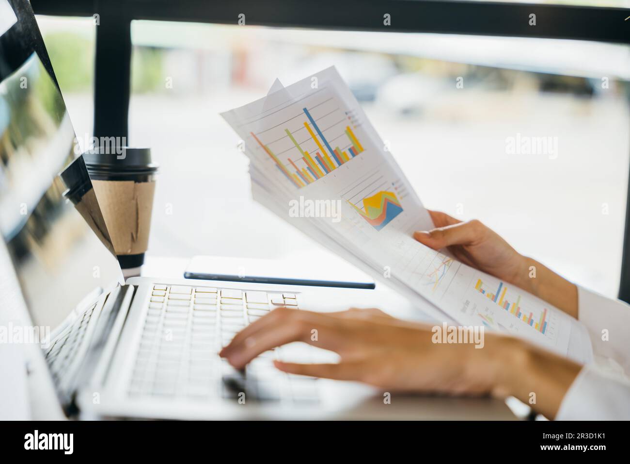 Freelance female hold paperwork documents paper graphs and using laptop ...