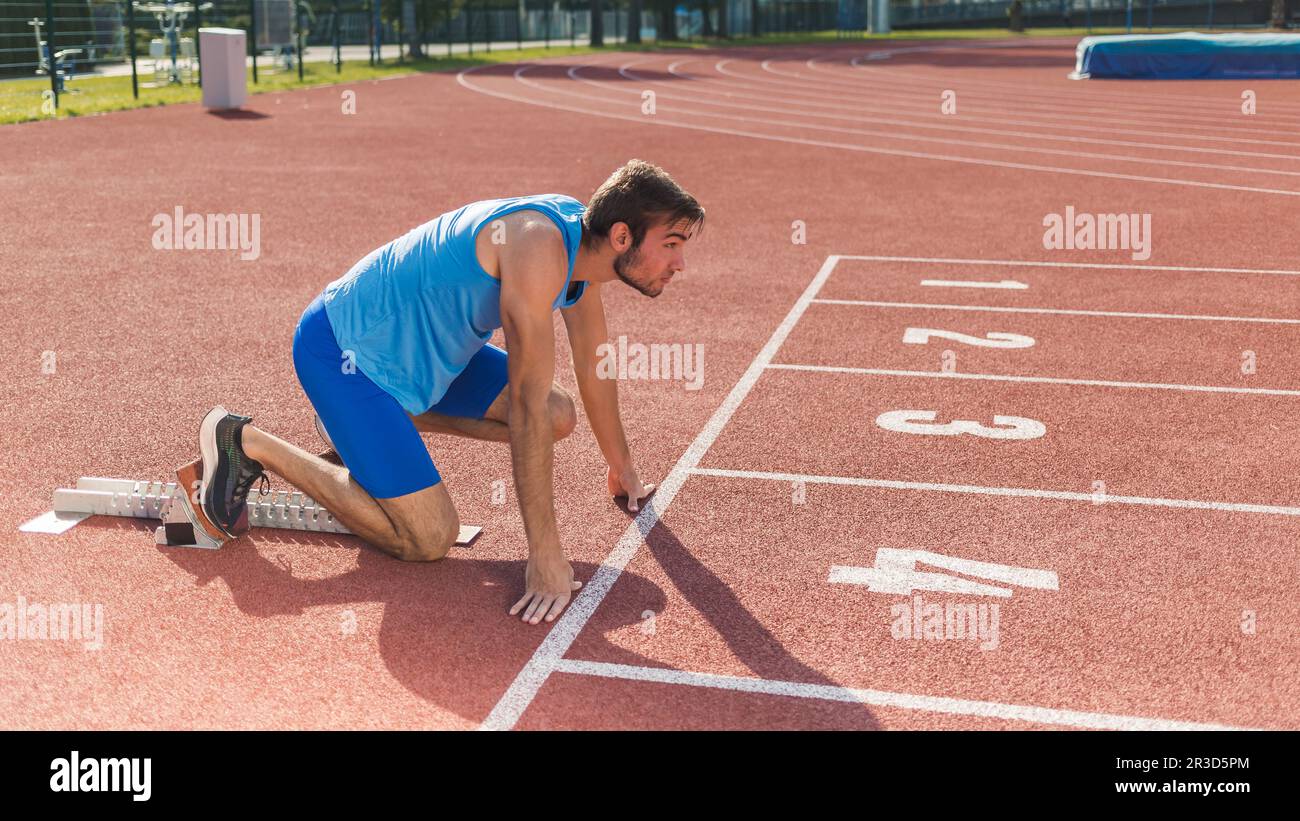 Sideways view male professional athlete preparing beyond start line in ...