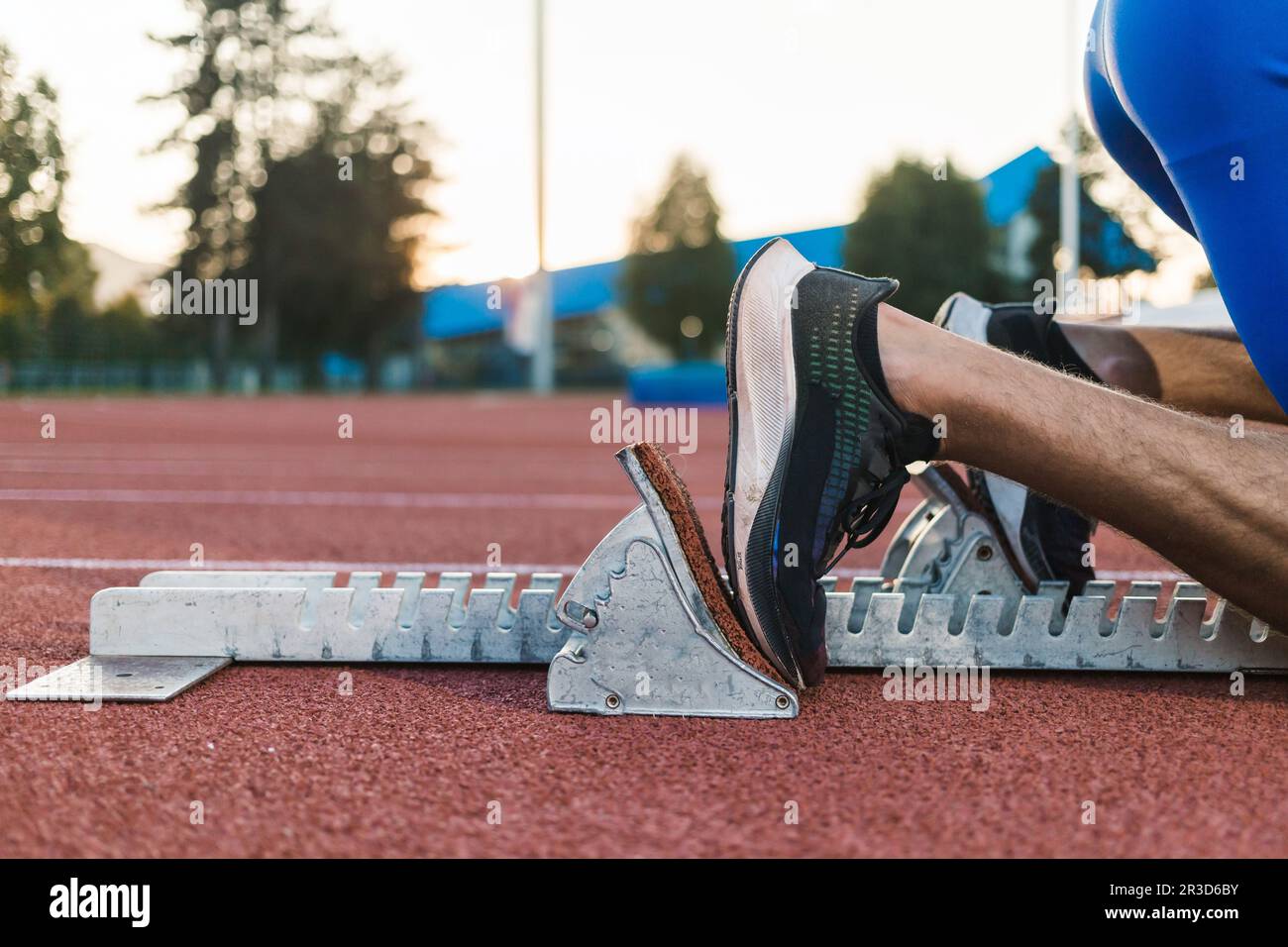 Male sprinter feet, in black sneakers, pushing off from the starting ...