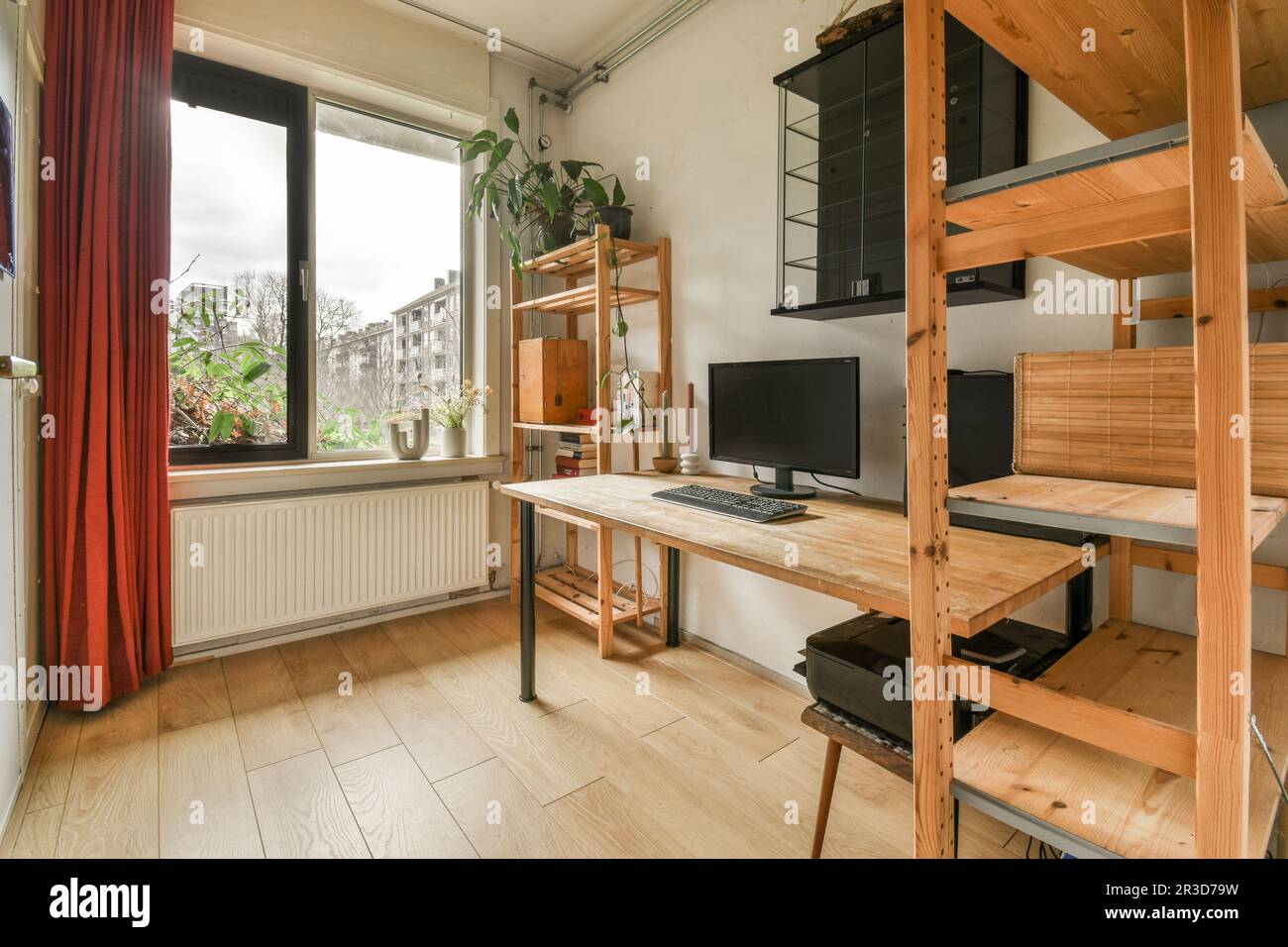 a small room with a desk, computer monitor and television on the table ...
