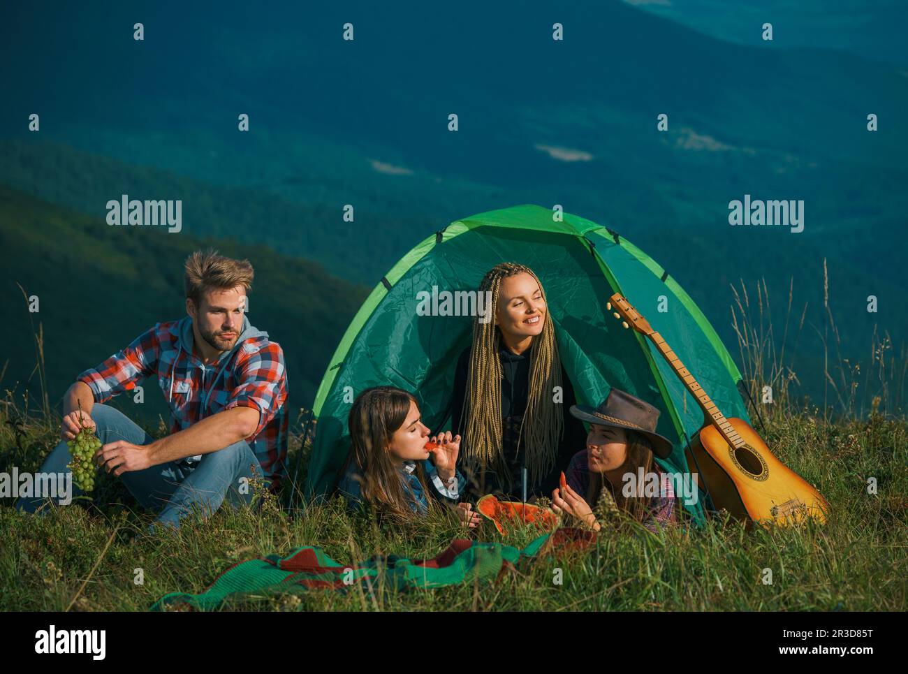 Group of happy friends in tent eating watermelon at camping. Camping ...