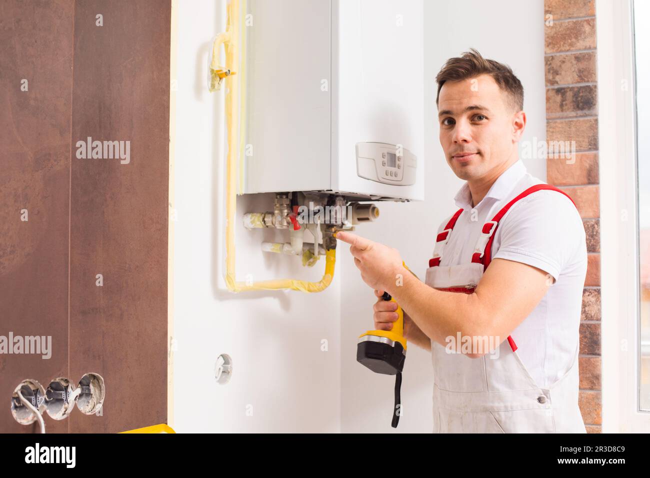The plumber works with boiler at the kitchen Stock Photo - Alamy