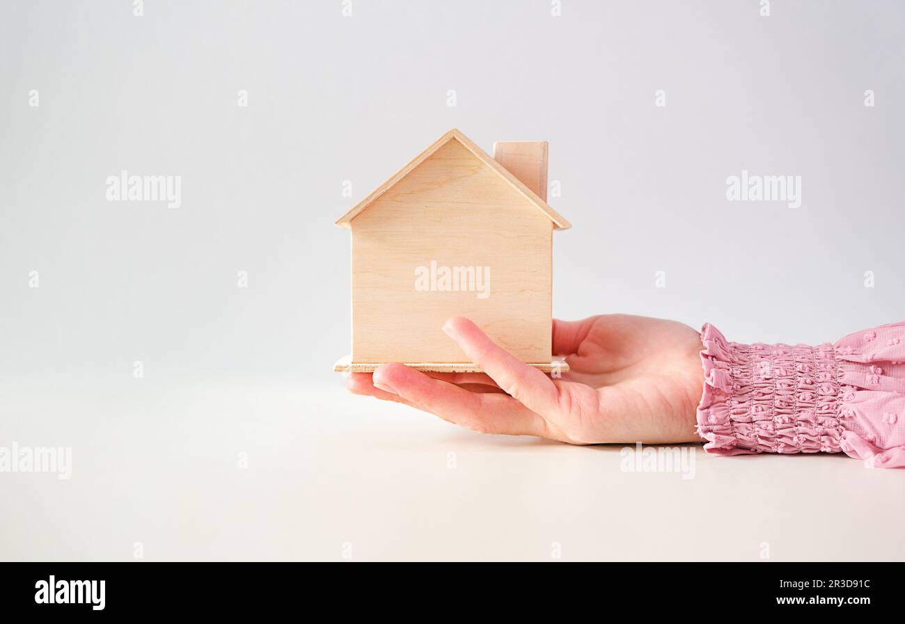 Tiny house in female hand isolated on white Stock Photo - Alamy